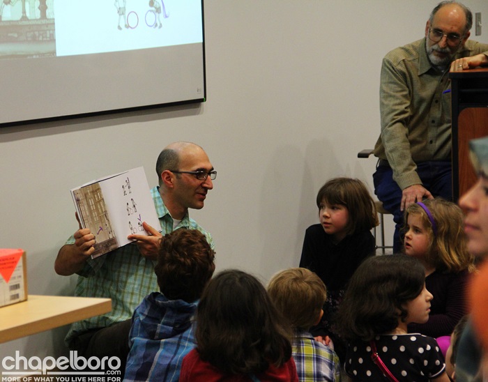 Aaron Becker reads for the kids while his father, Hank Becker, looks on ...